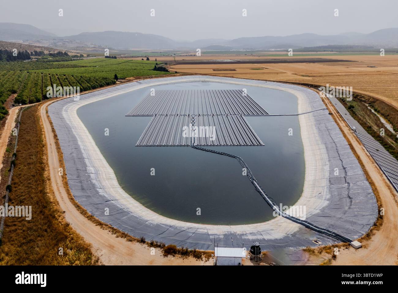 Aerial view of solar panels floating on a reservoir, reflecting the sky ...