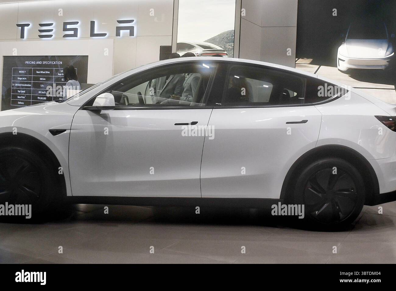 Tesla launches in India People view vehicles in the Tesla showroom at ...