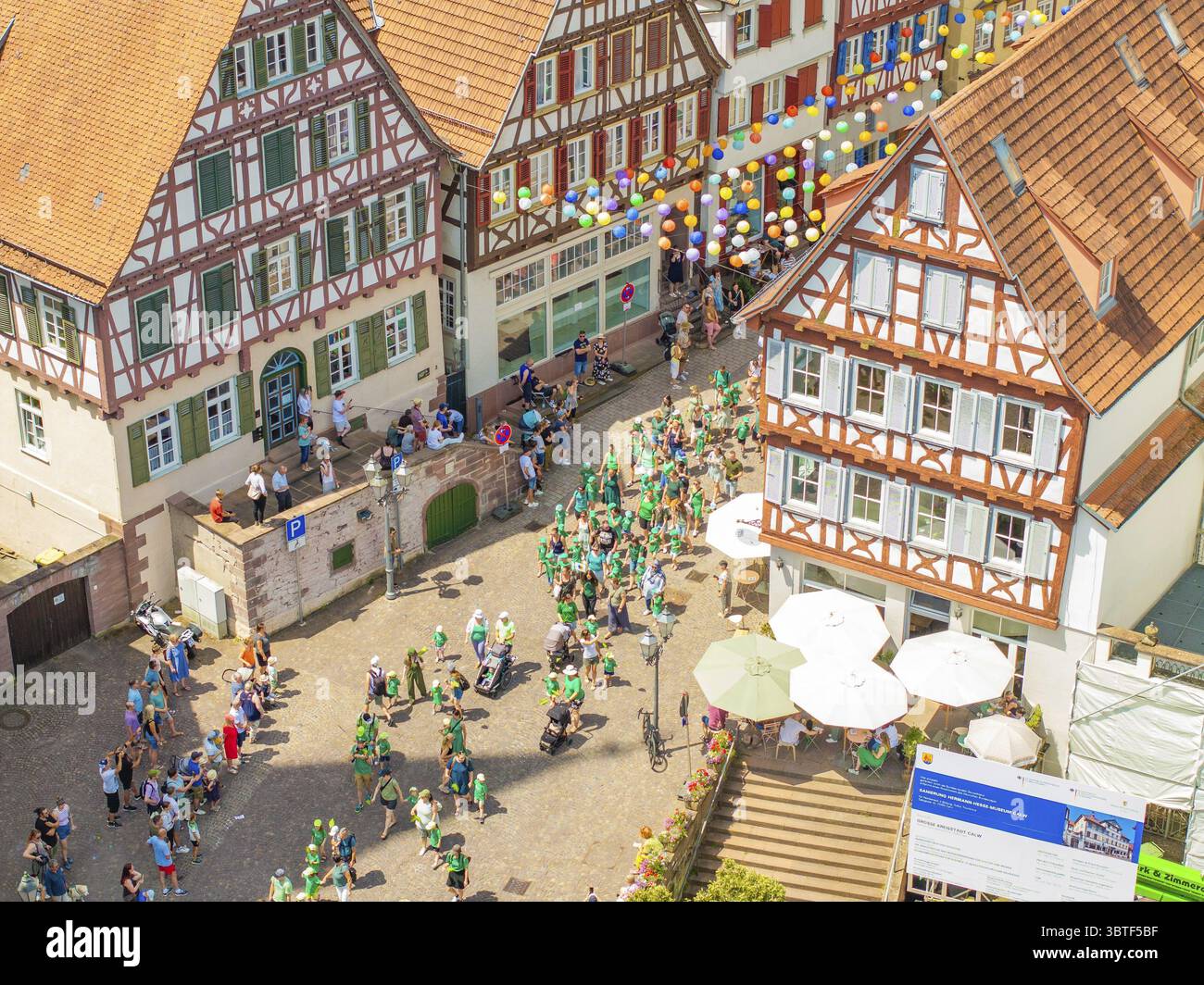 Aerial view of a group of people at a town festival, decorated with ...