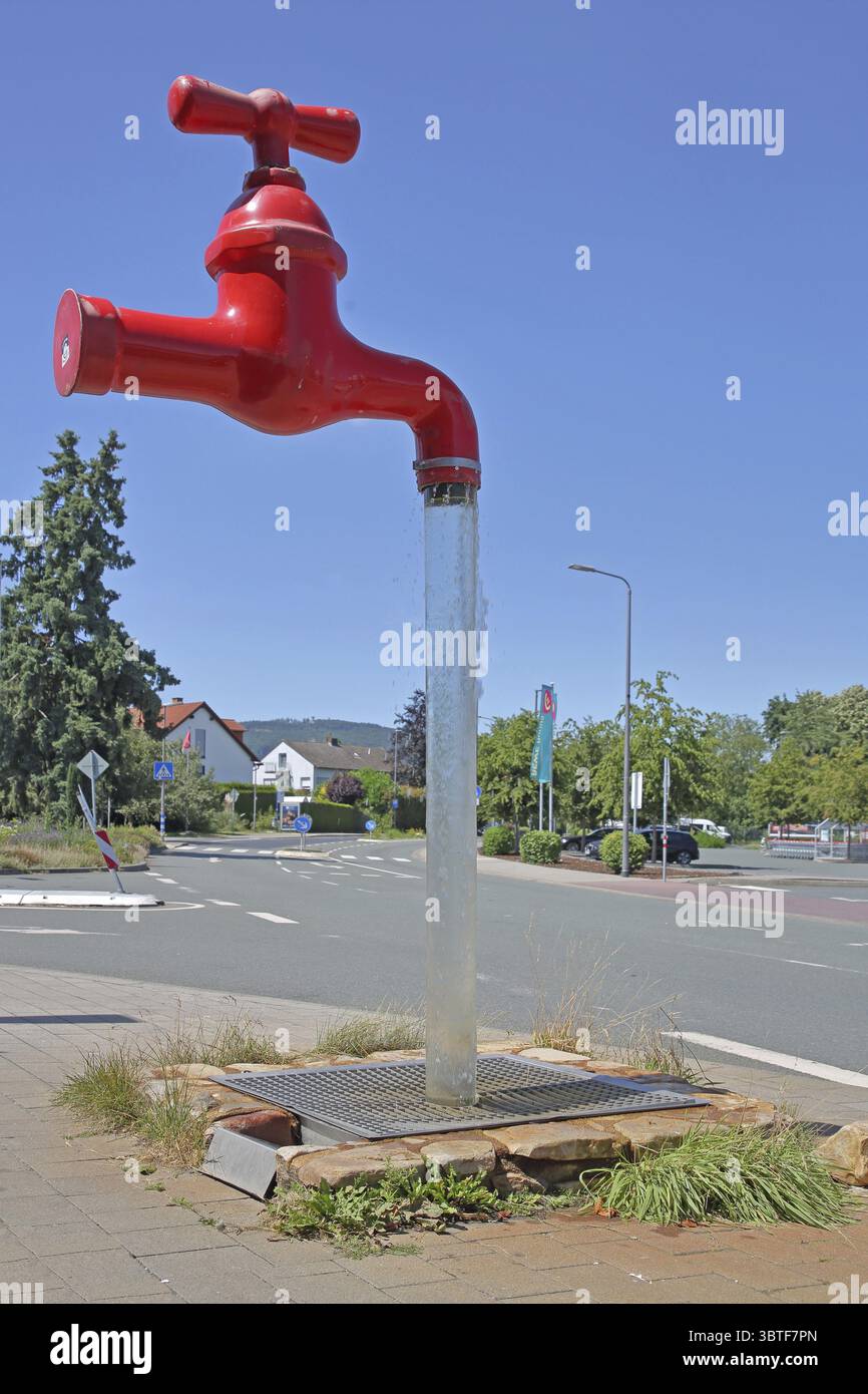Red free-standing tap with water jet, fountain, modern art, sculpture ...