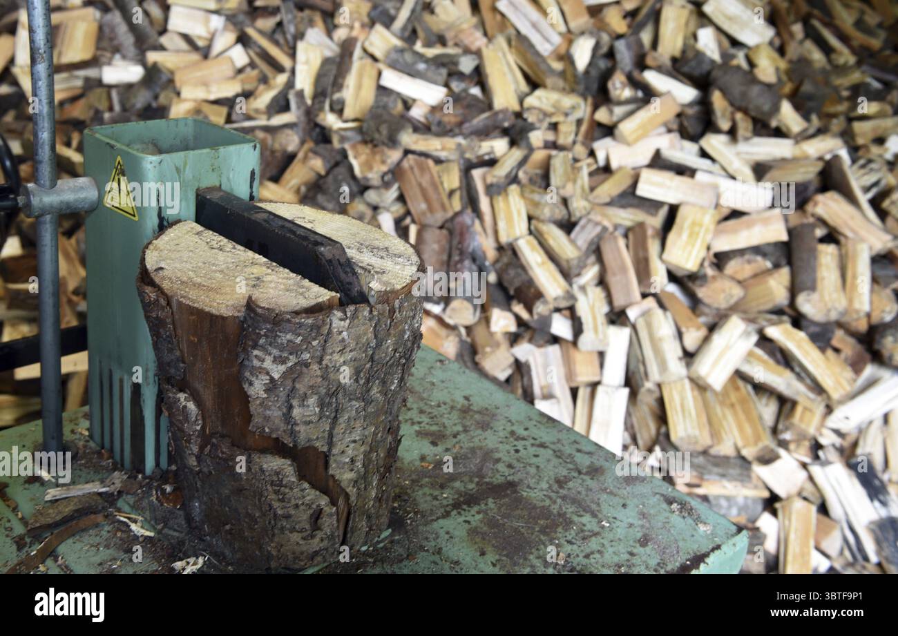 Firewood, splitting with a log splitter, axe Stock Photo - Alamy