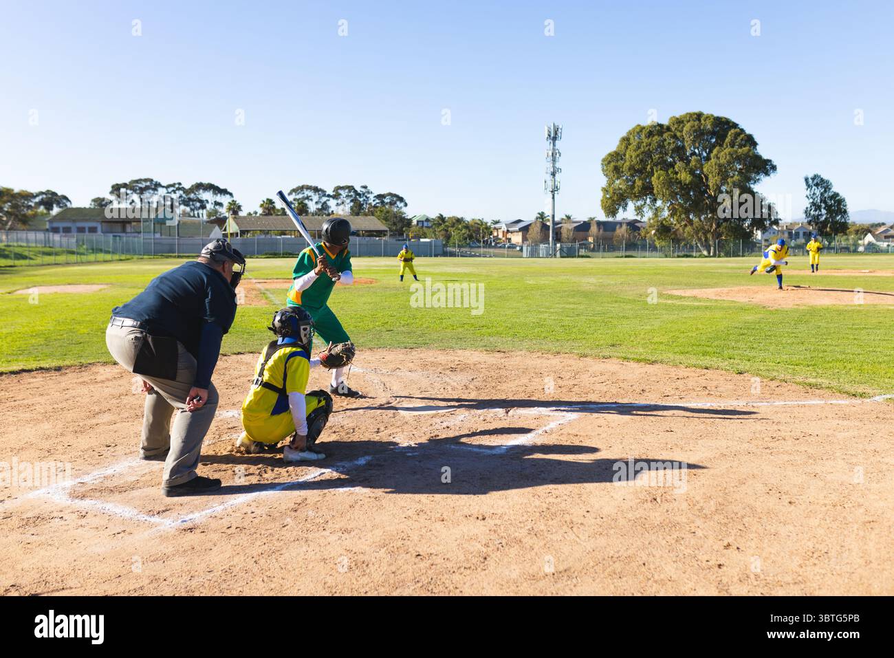 Mature male batter standing ready to swing bat in chalked batter's box ...