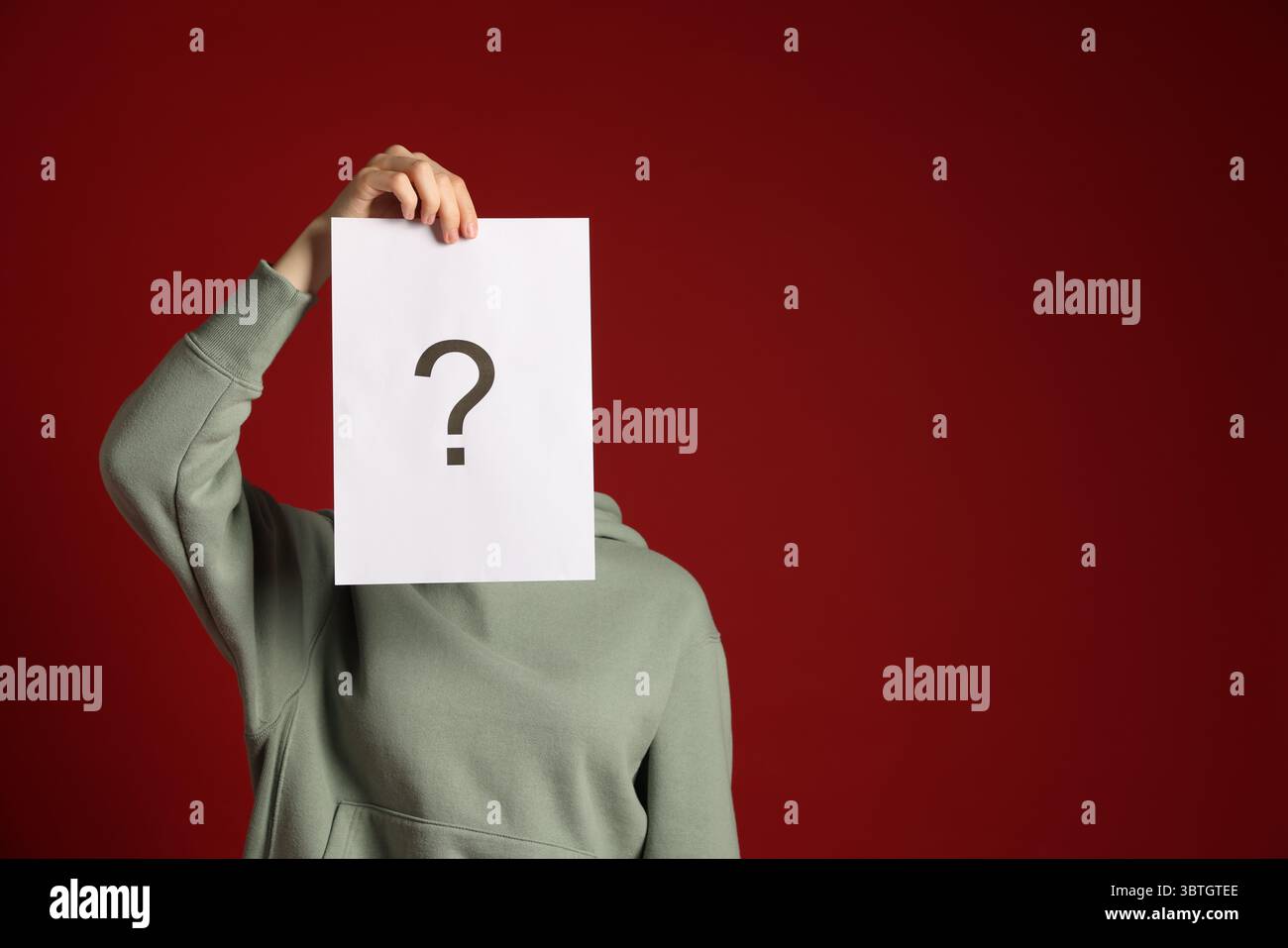 Anonymity. Woman hiding behind paper sheet with question mark on dark ...
