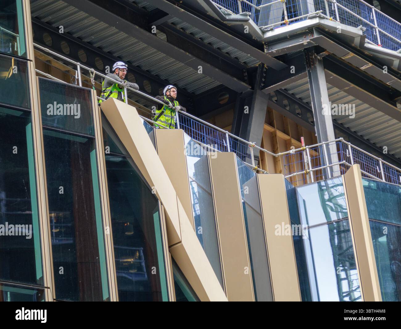 Builders look out from the structural frame of 2 Finsbury Avenue, a ...