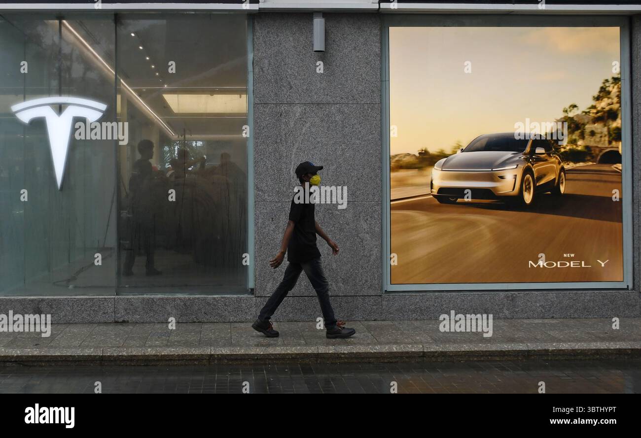 A man walks past a Tesla experience centre ahead of its launch inside ...