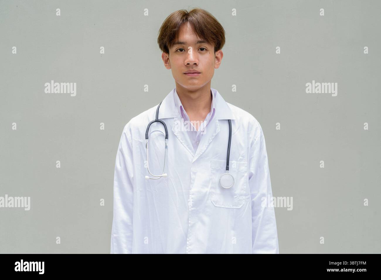 Young Asian healthcare worker wearing lab coat Stock Photo - Alamy
