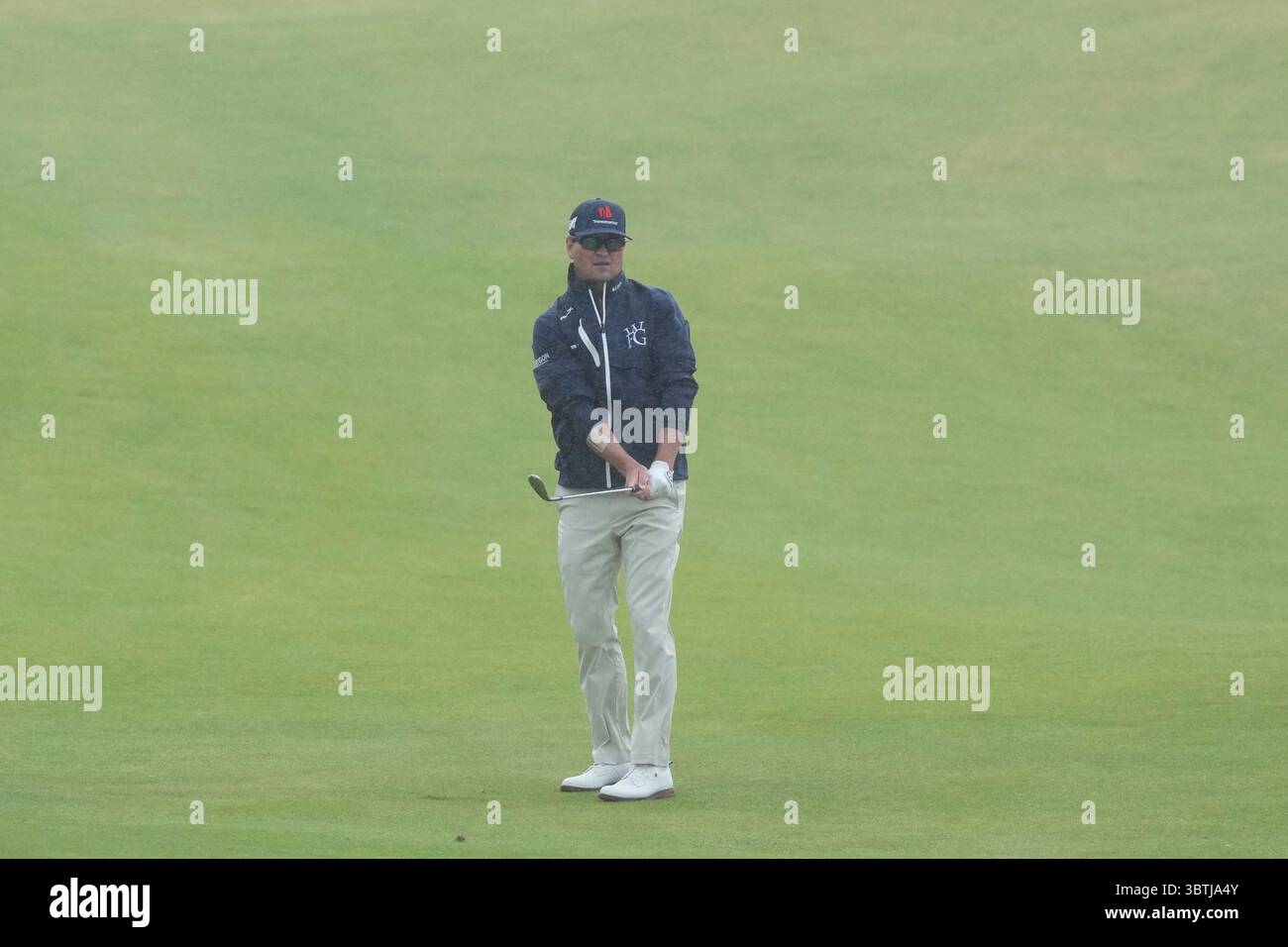 Zach Johnson of the United States plays to the 8th green in the rain ...