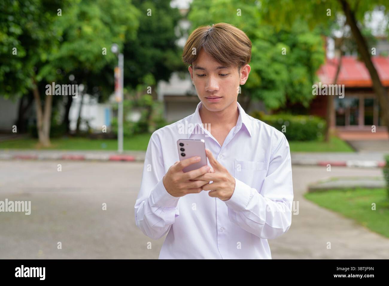 Non binary Asian university student in college campus Stock Photo - Alamy