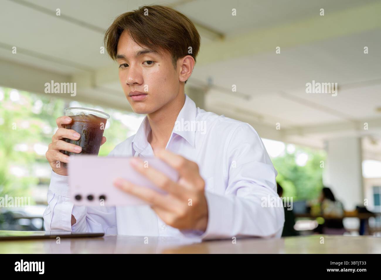 Non binary Asian university student in college campus Stock Photo - Alamy