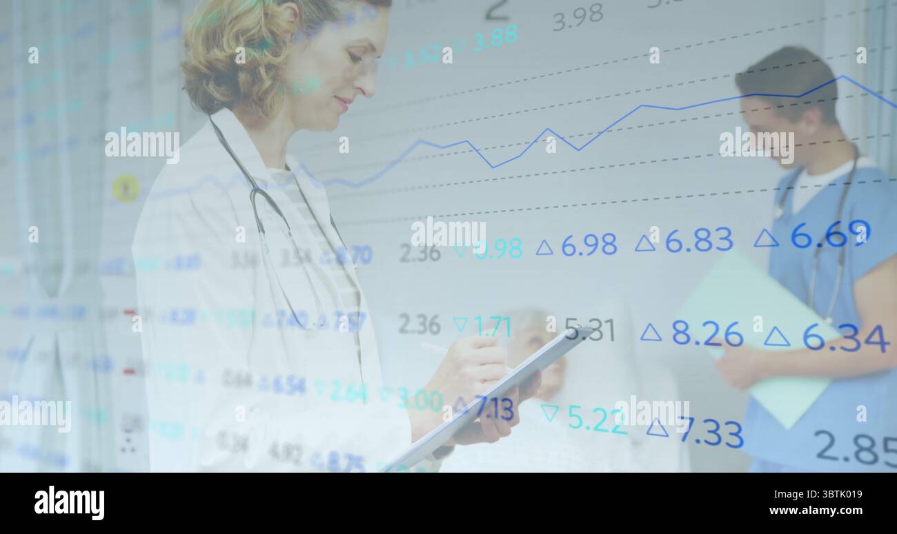 Female doctor with stethoscope reviewing tablet in ward, nurse ...