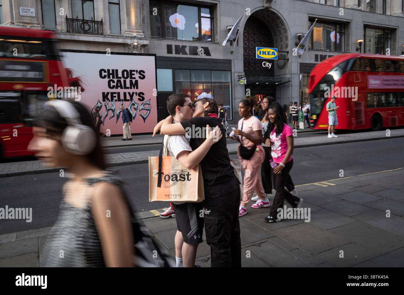 A young couple share a hug and a kiss outside Oxford Circus underground ...