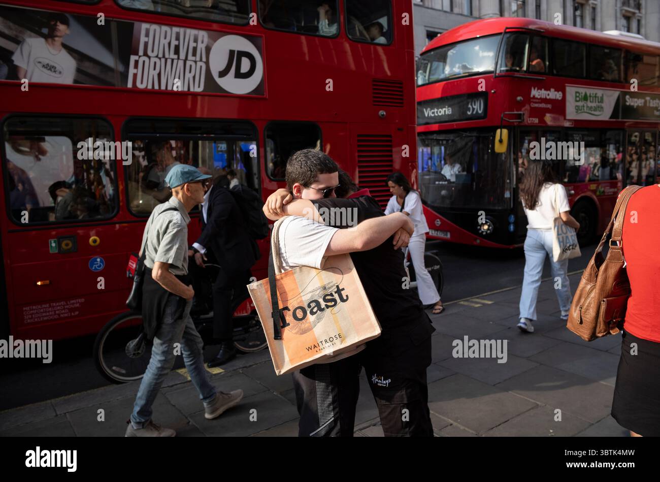 A young couple share a hug and a kiss outside Oxford Circus underground ...