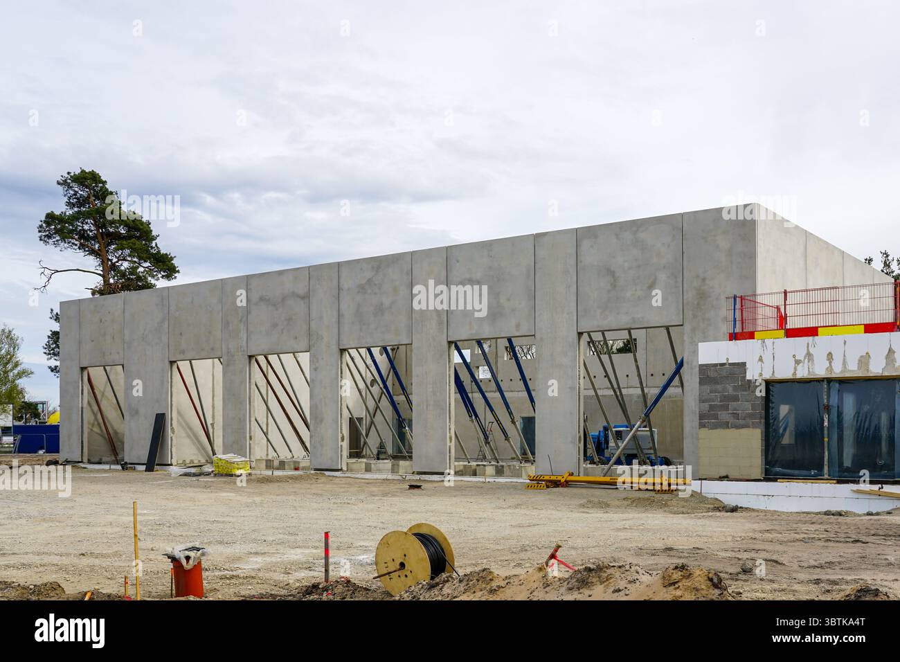 A large-scale concrete building is in the early stages of construction ...