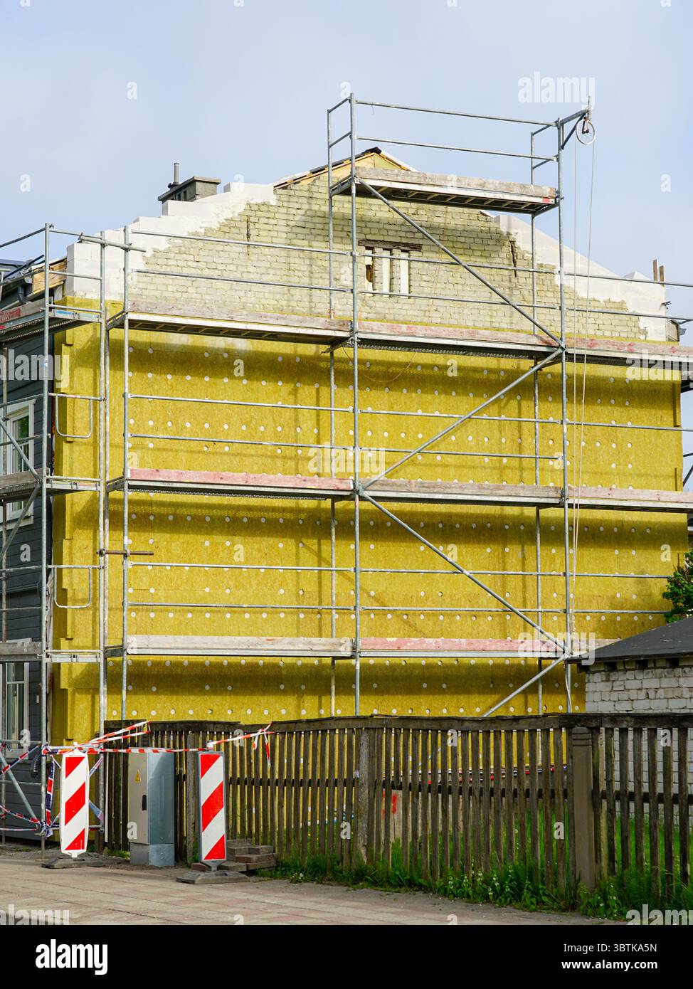 A residential building is seen mid-renovation with scaffolding and ...