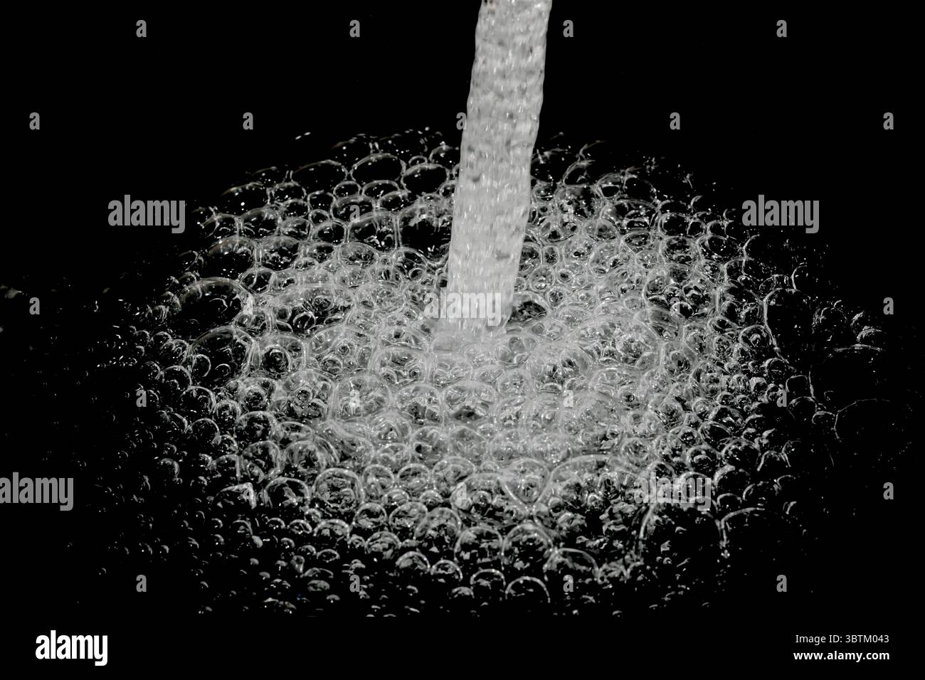 A jet of clean tap water with pressure fills the container with the formation of air bubbles ...
