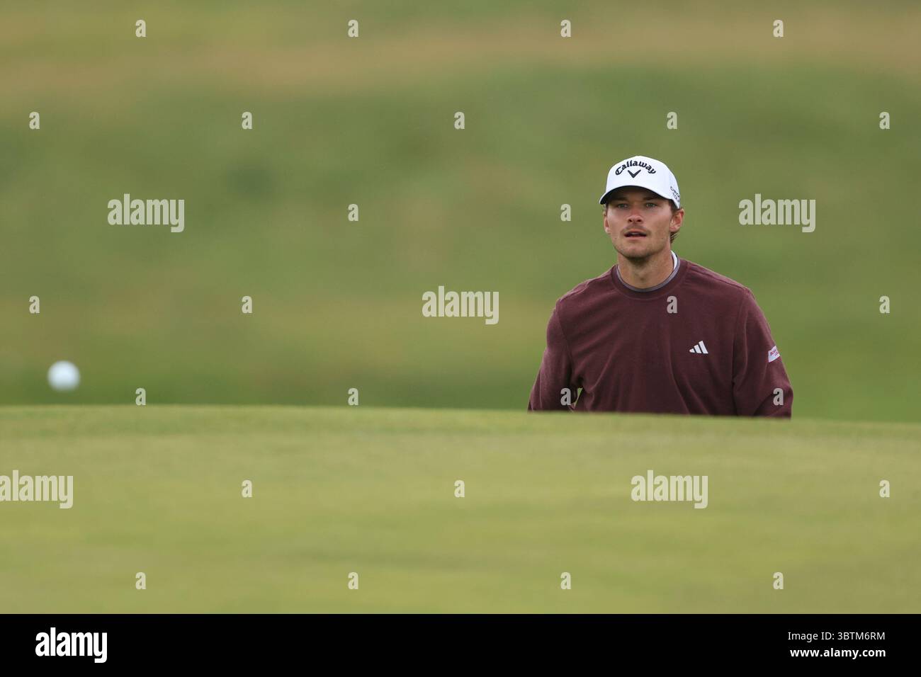 Nicolai Hojgaard of Denmark watches his ball as he plays the 15th hole ...