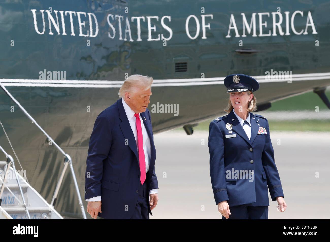 President Donald Trump is escorted by Air Force Col. Angela F. Ochoa ...