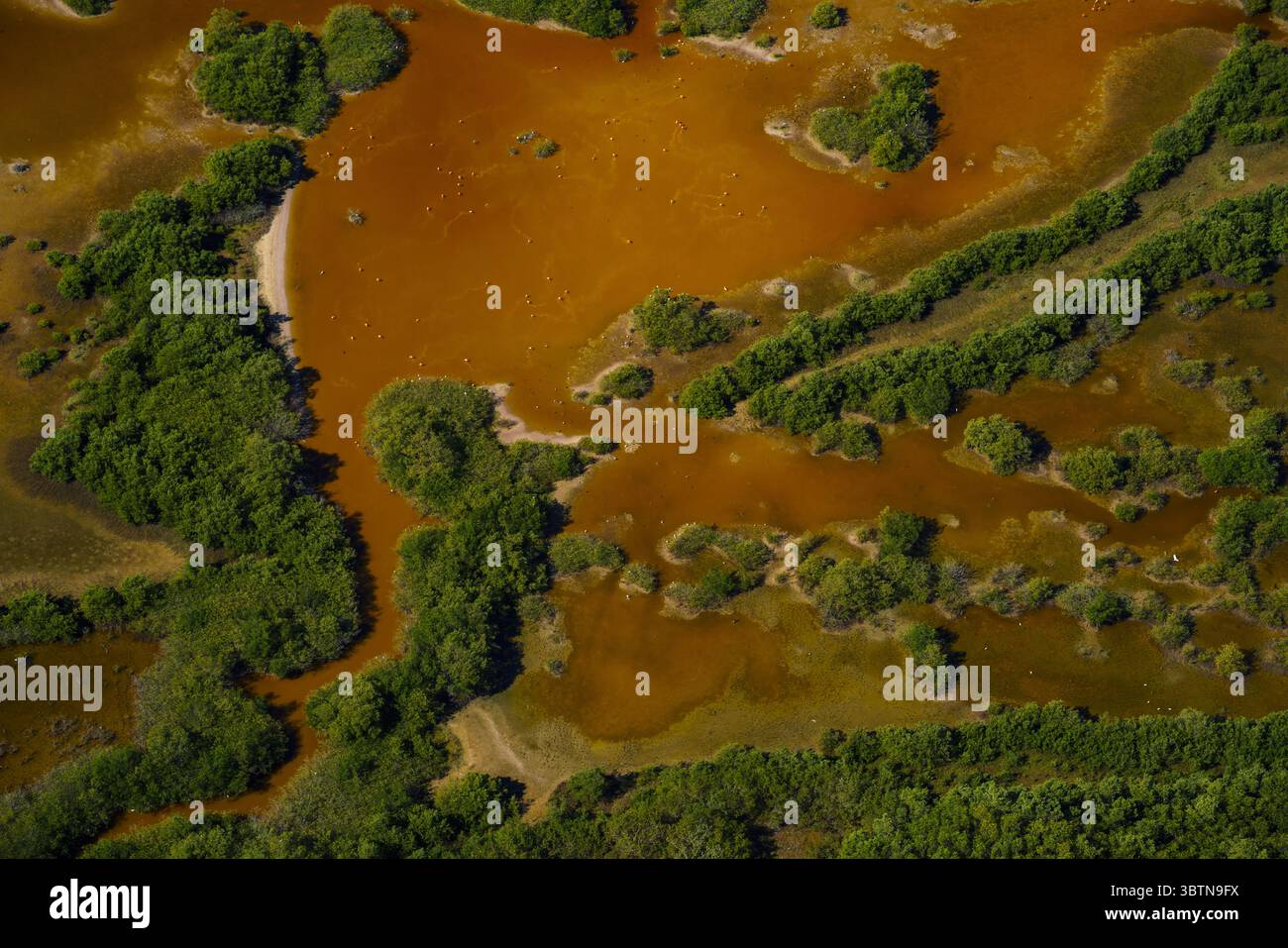 Aerial view of the deep orange water contrasting with the vibrant green ...