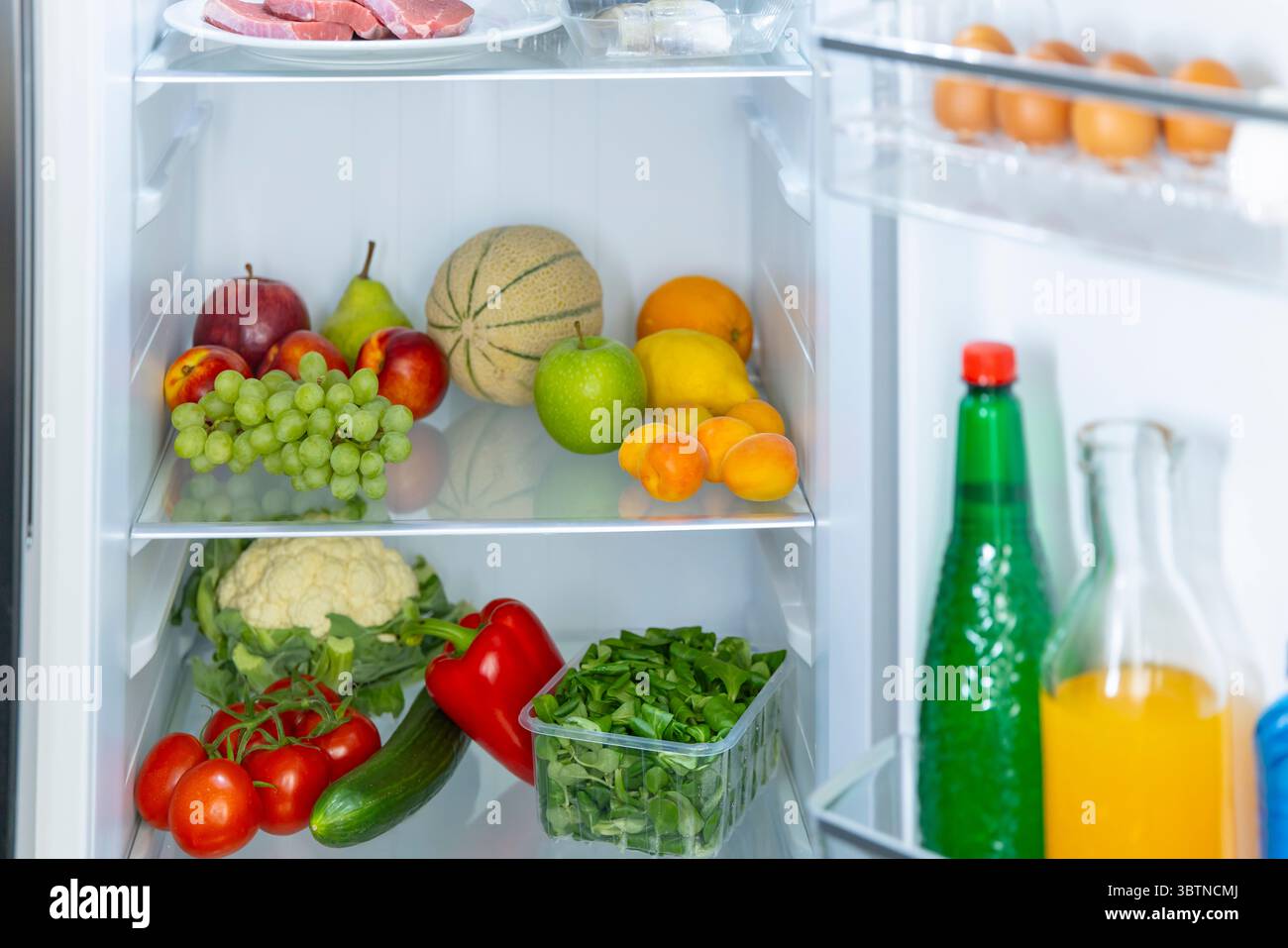 Modern refrigerator full of healthy food, fruits, vegetables, eggs and ...