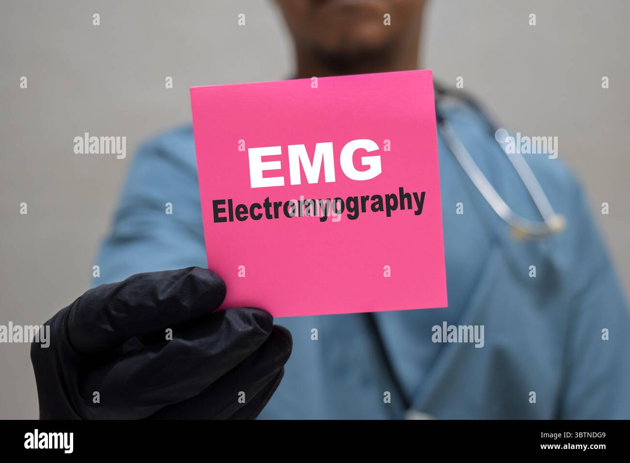 Doctor holds in hands a card with the name of the Electromyography ...