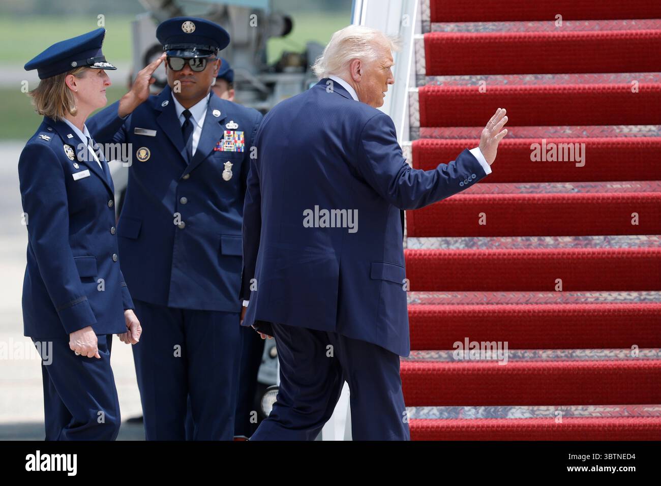 President Donald Trump, center, waves as he is escorted by Air Force ...