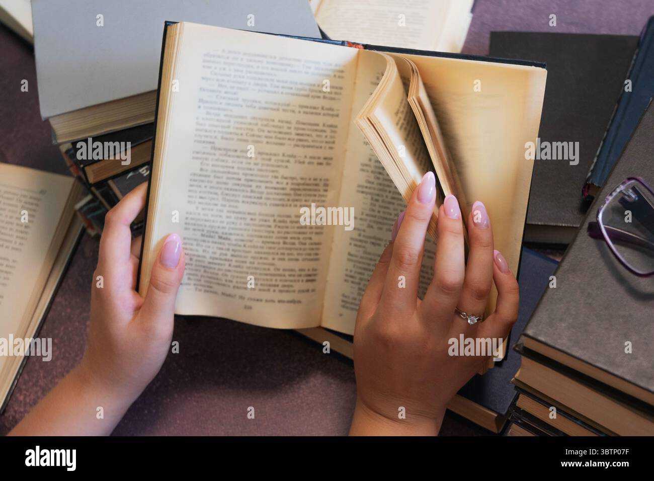 Flipping Through Book Pages at Library Table Stock Photo - Alamy