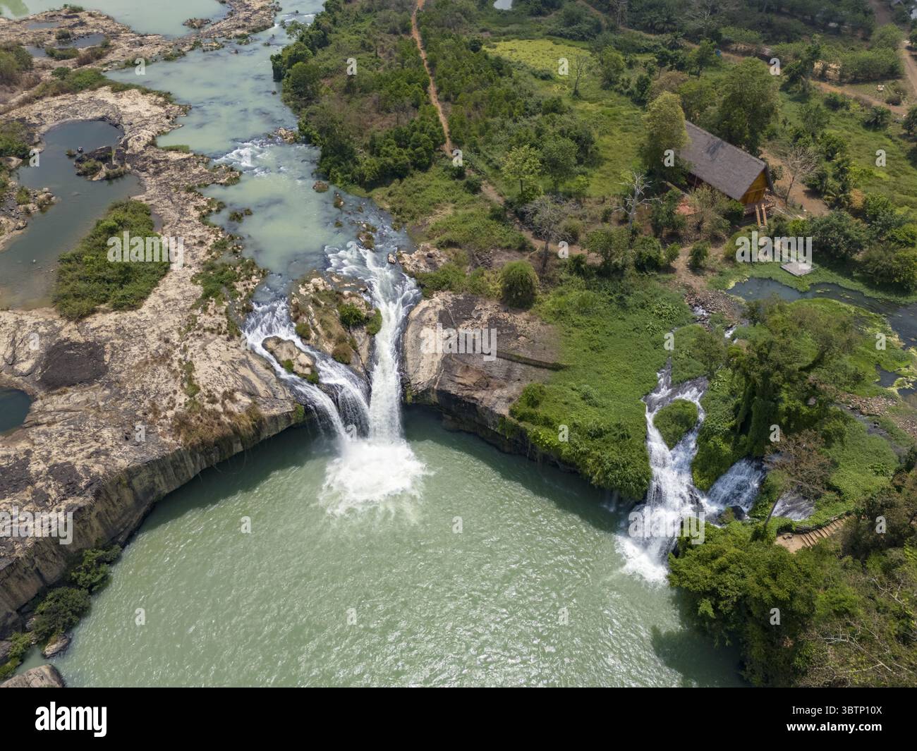 Aerial view of powerful waterfalls cascading over rugged cliffs into a ...