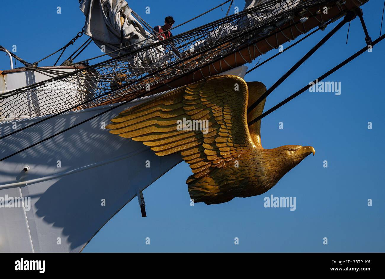 A crew member stands at the bow of the U.S Coast Guard Barque Eagle ...