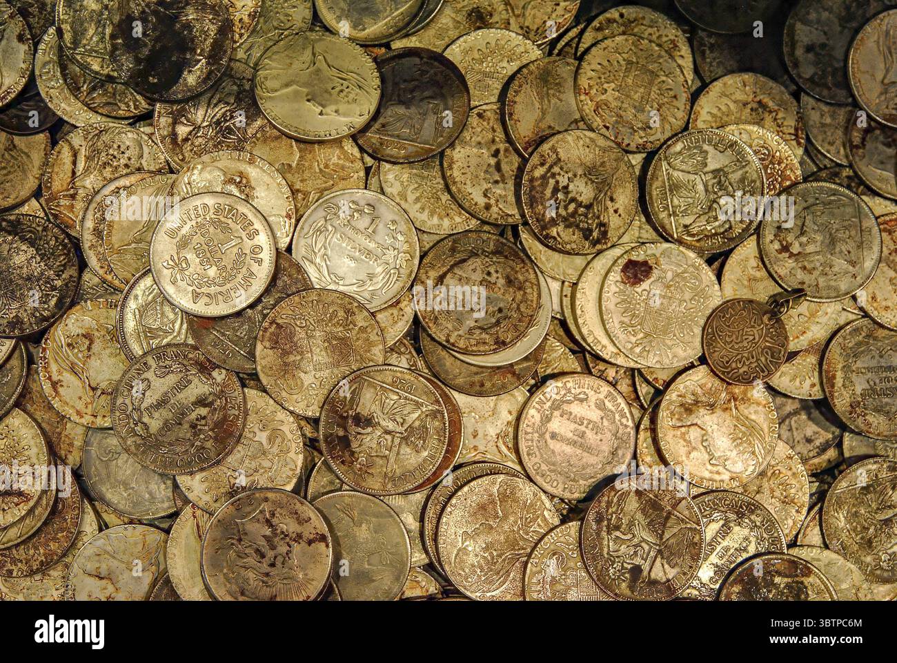 Old silver and bronze coins from various countries in a close-up view ...