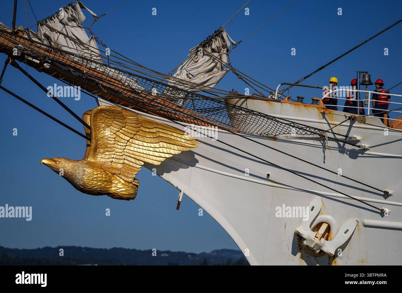 Crew members stand at the bow of the U.S Coast Guard Barque Eagle tall ...