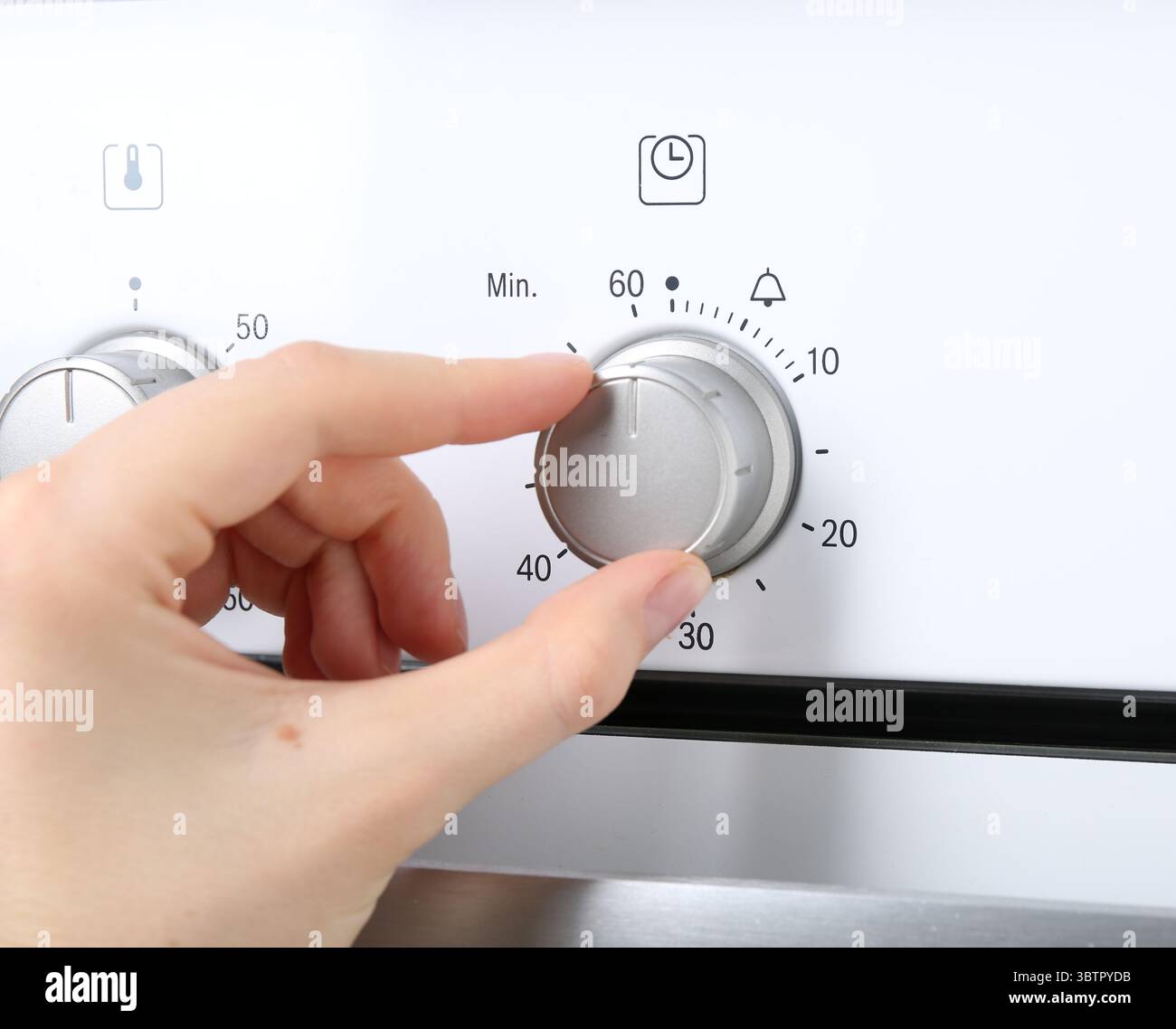 Maximum concept. Woman turning on oven, closeup Stock Photo - Alamy