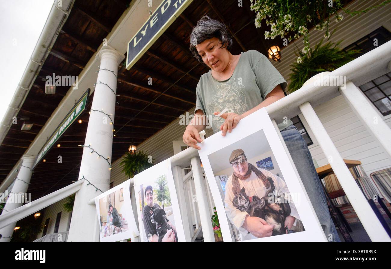 Robin Morgan of Brattleboro, Vt., hangs up photos of Scott Garvey, who ...