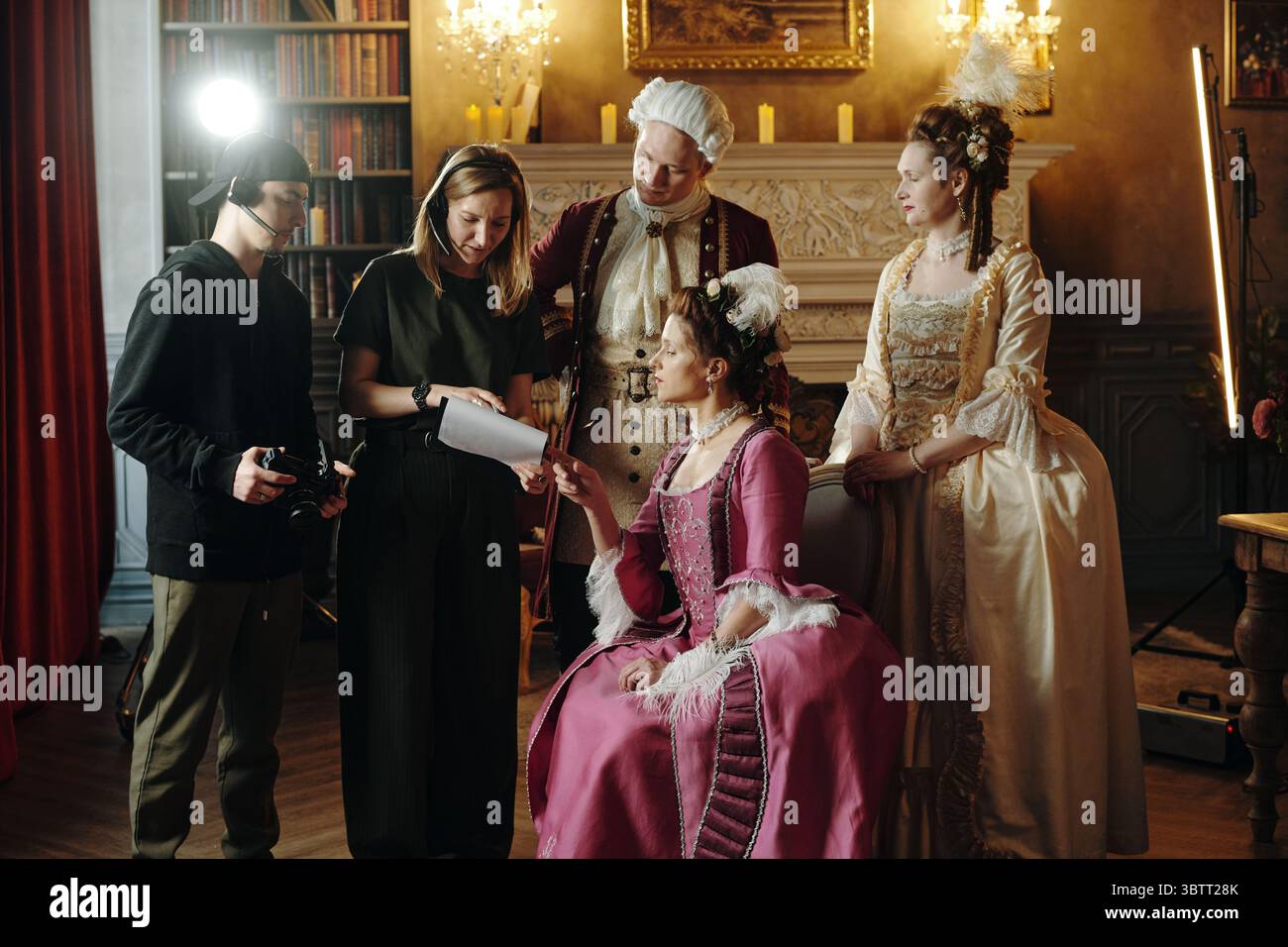 Multiethnic group including young adult woman in Baroque dress sitting ...