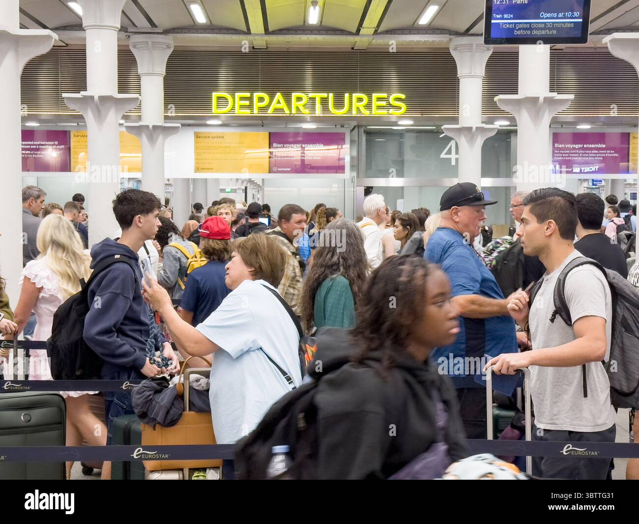 Travellers Carrying Suitcases and Backpacks Queue at Departure Gate for ...