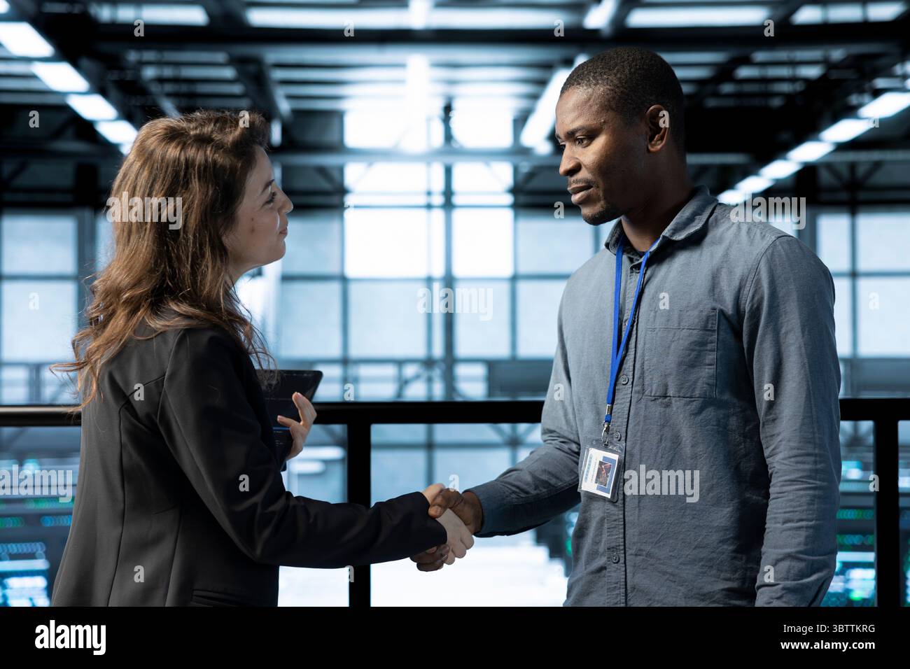 Manager meeting with computer scientist in data center, coming to ...