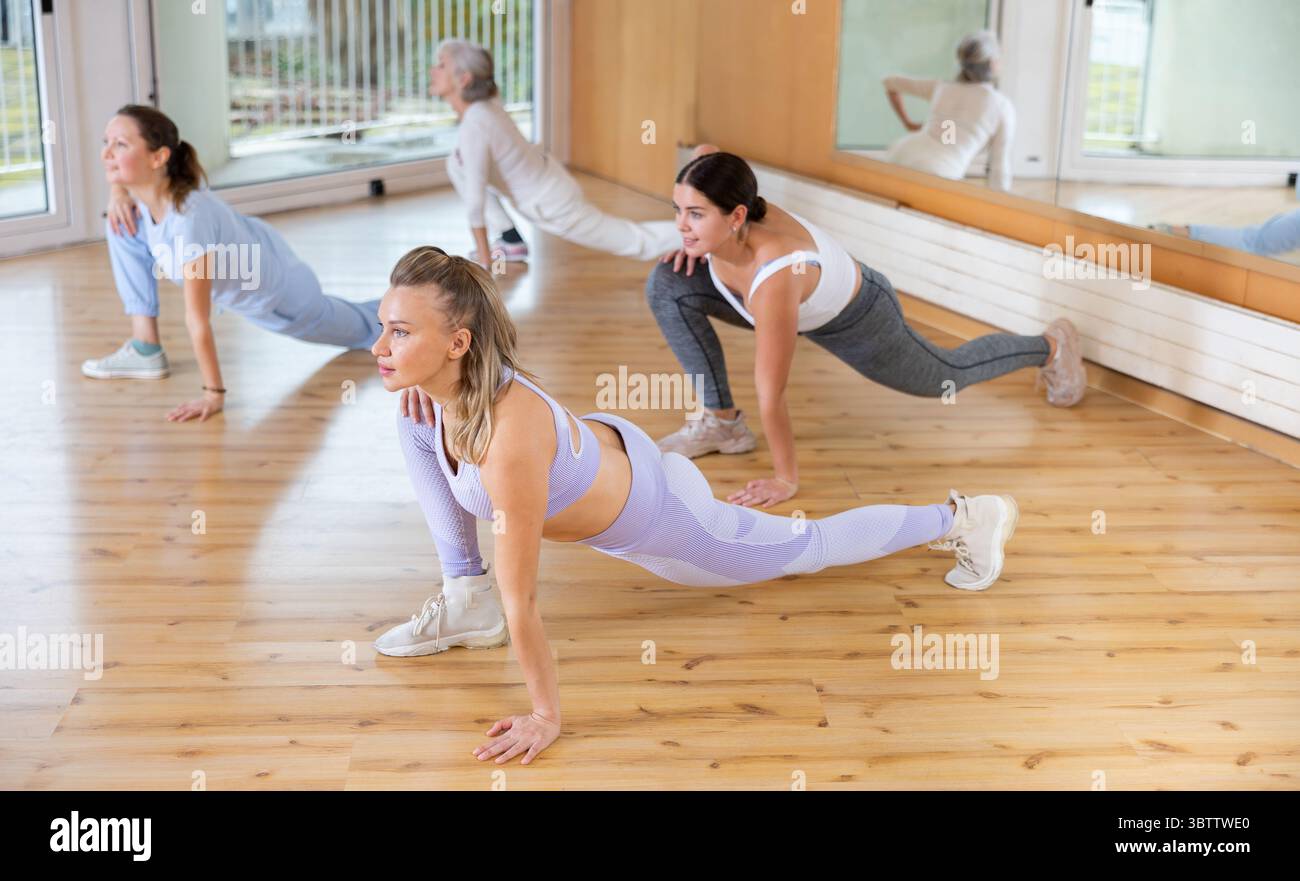 Dynamic women doing stretching in training hall Stock Photo - Alamy