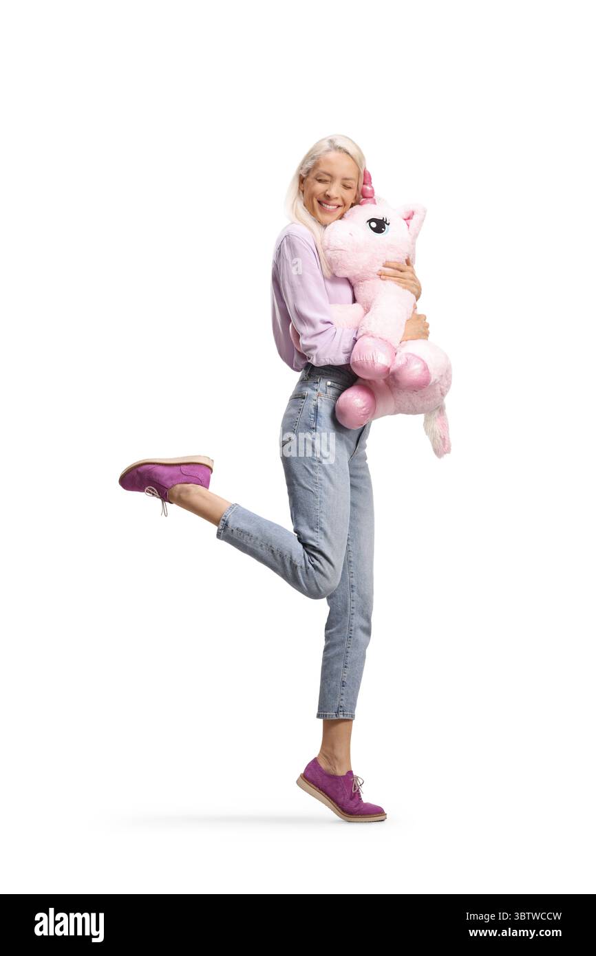 Happy woman hugging a big pink unicorn isolated on white background ...