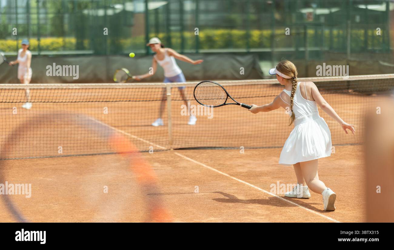 Concentrated sporty girl with tennis racquet and ball in her hands ...