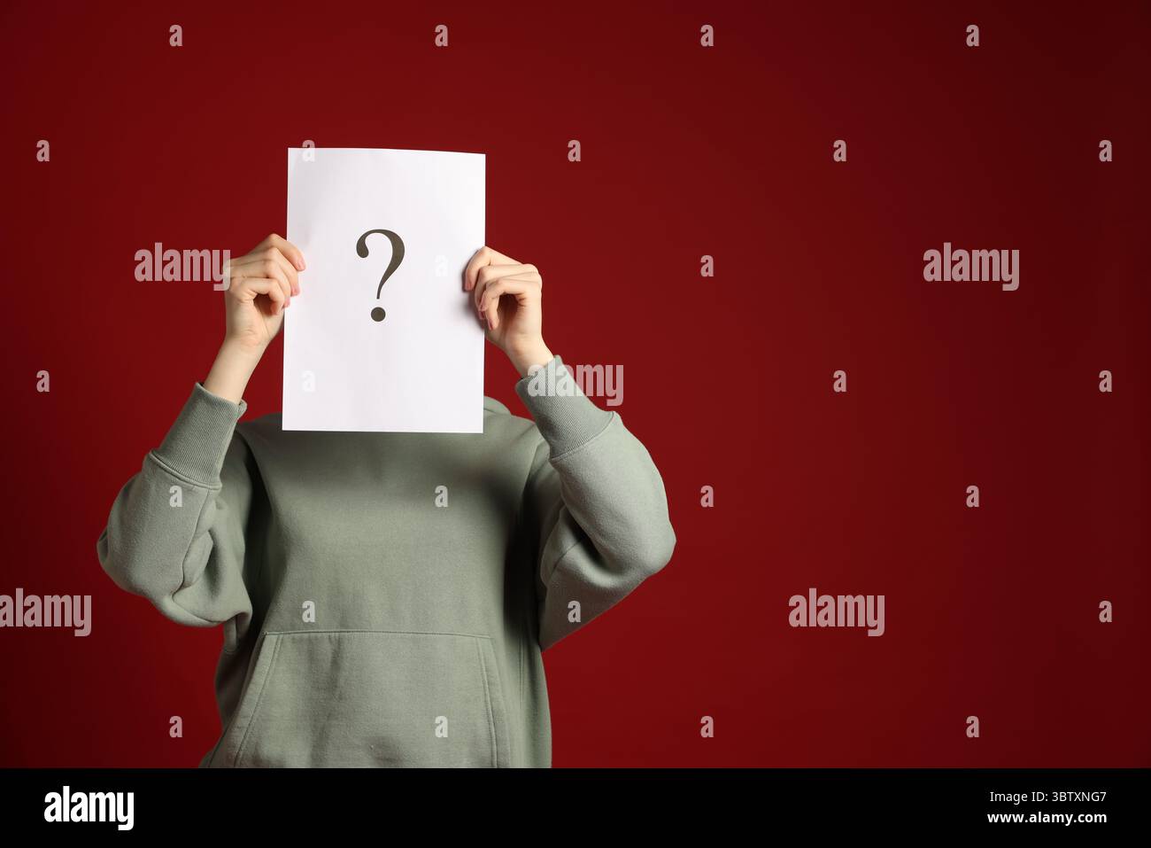 Anonymity. Woman hiding behind paper sheet with question mark on dark ...