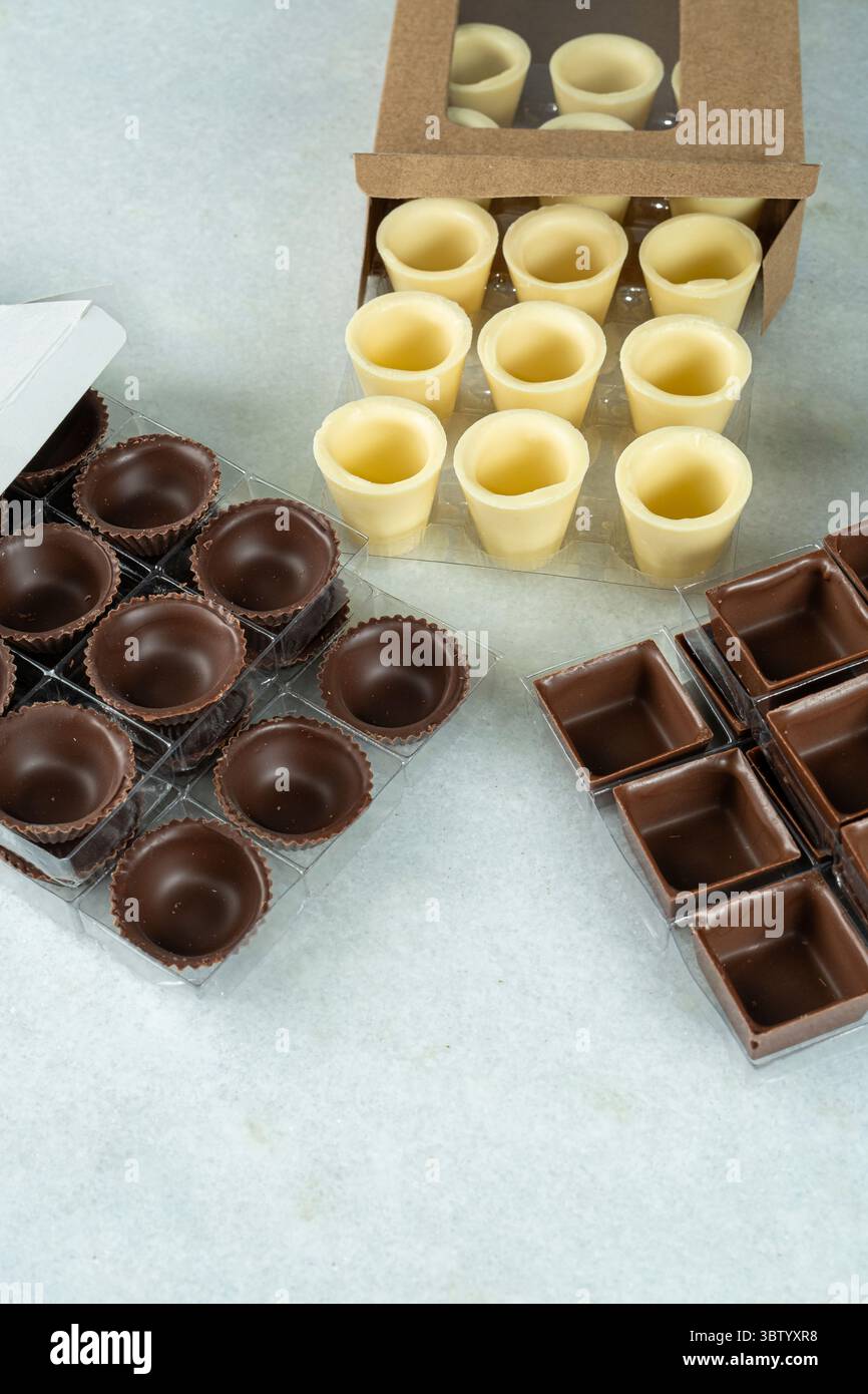 Various types of chocolates in different shapes inside boxes vertical ...