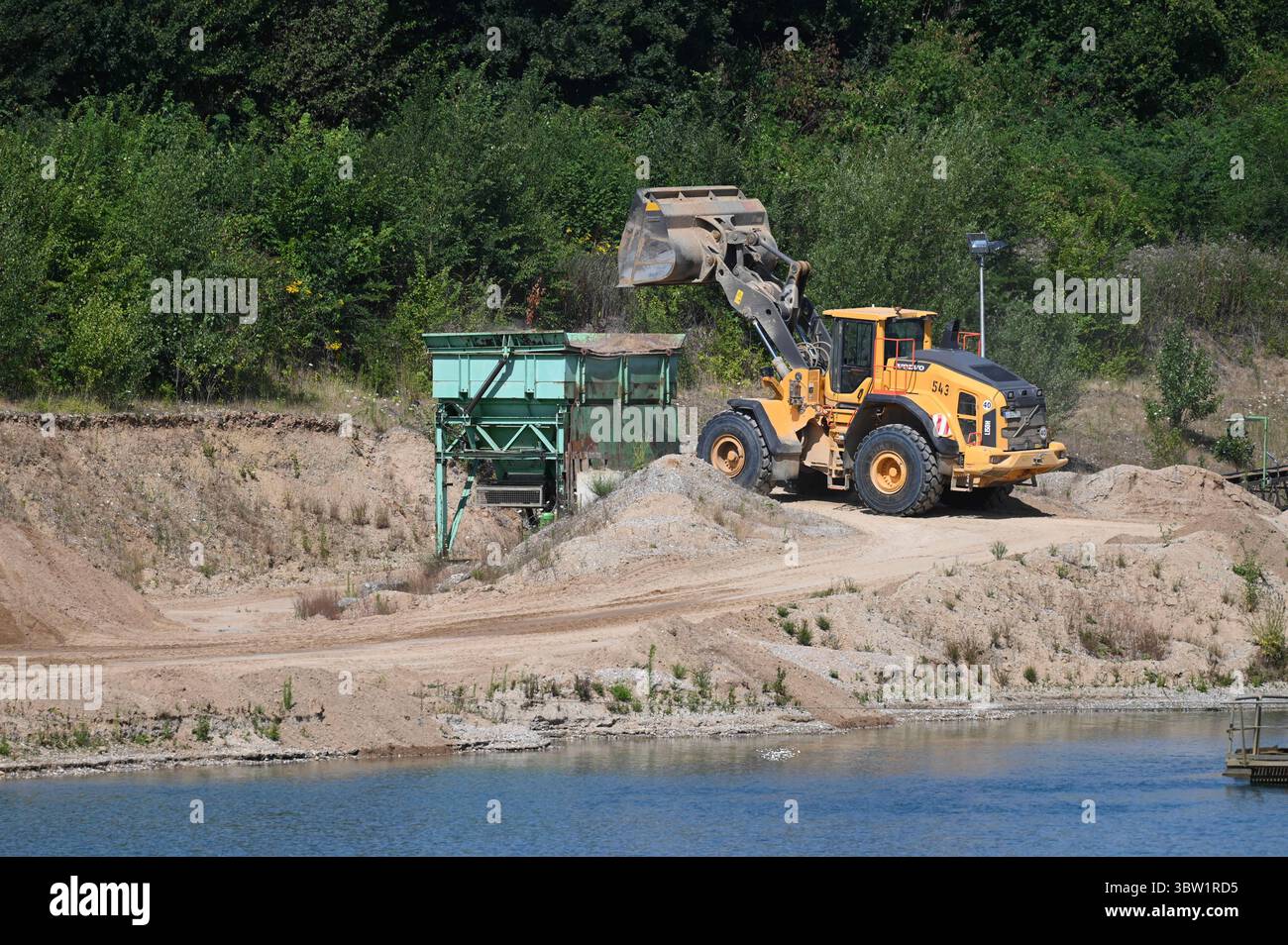 Ein Radlader laedt Sand in einen Trichter, an einem Baggersee, am 15.07 ...