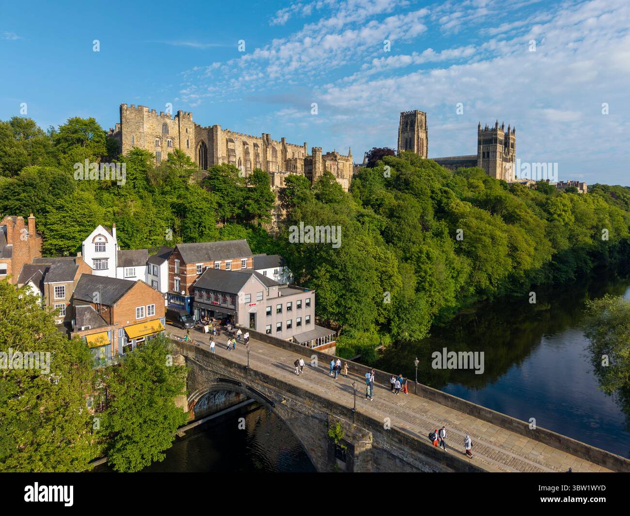 People walk over Framwellgate Bridge with Durham cathedral and castle ...