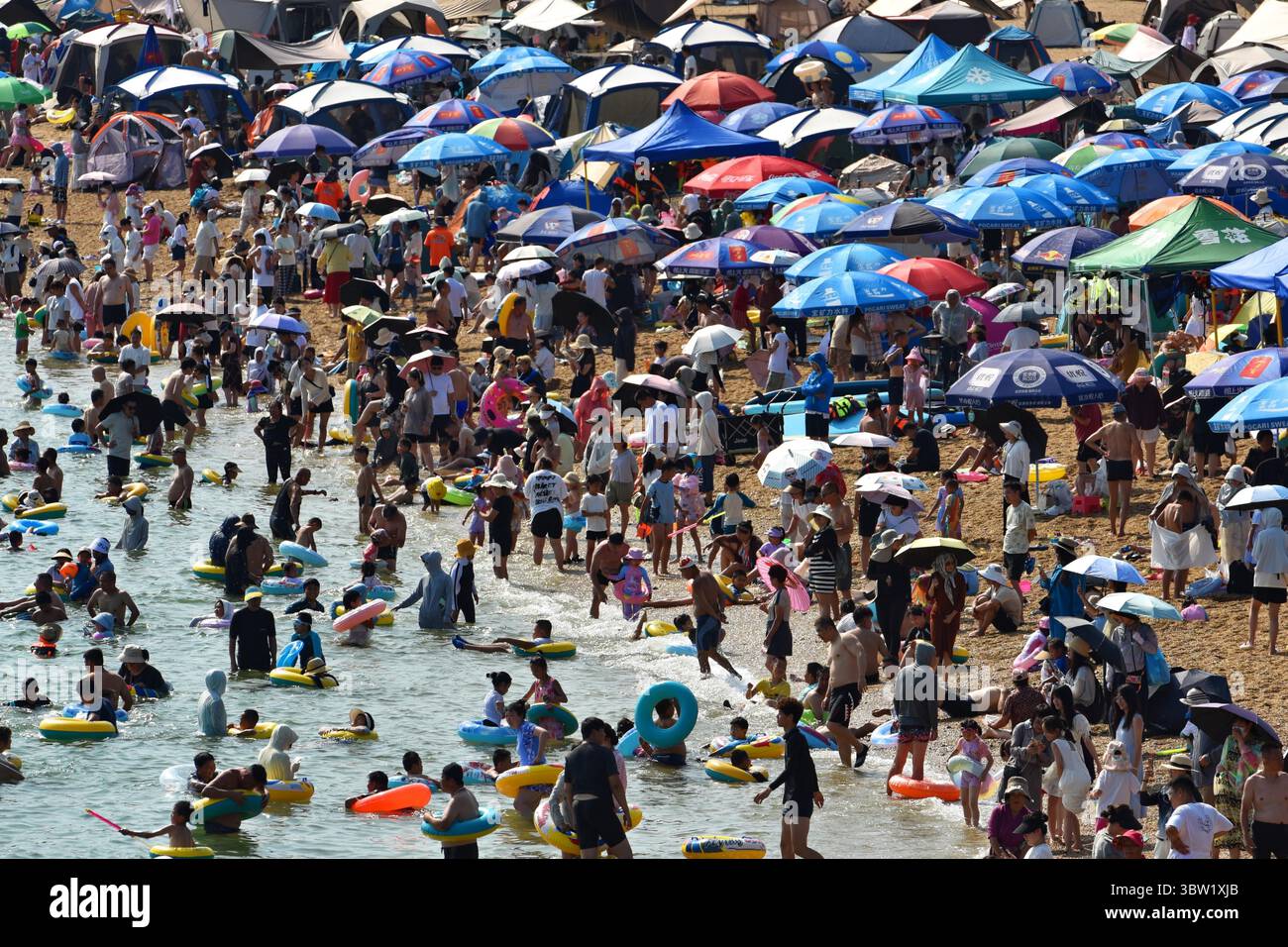 Tourists enjoy the summer time on the beach of Fujiazhuang Park in ...