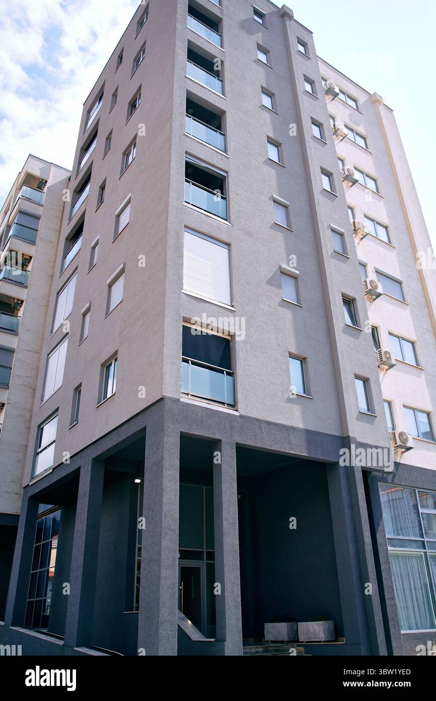 A modern high-rise building with a sleek facade, featuring glass ...