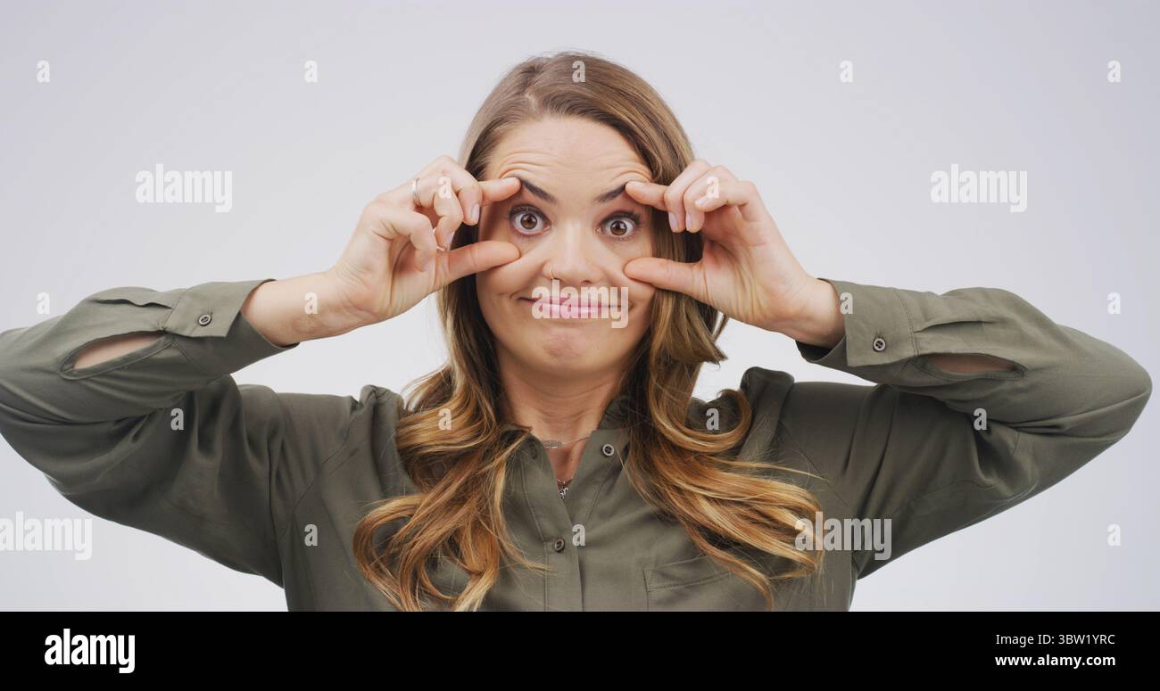 Goofy, funny face and portrait of woman in studio with open eyes, silly ...