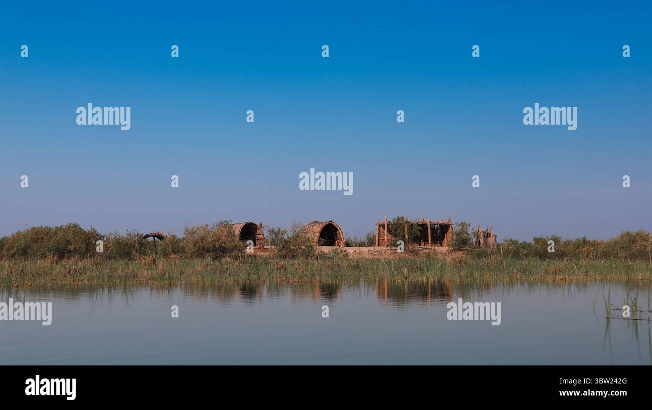 Traditional structures stand by calm waters in the marshes of Iraq ...