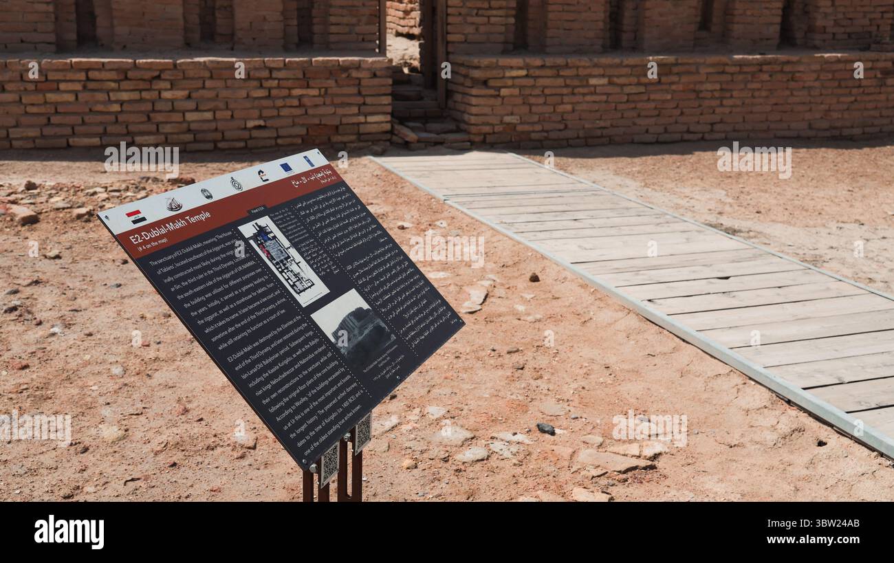Visitors walk along wooden paths at the Ziggurat of Ur, observing a ...