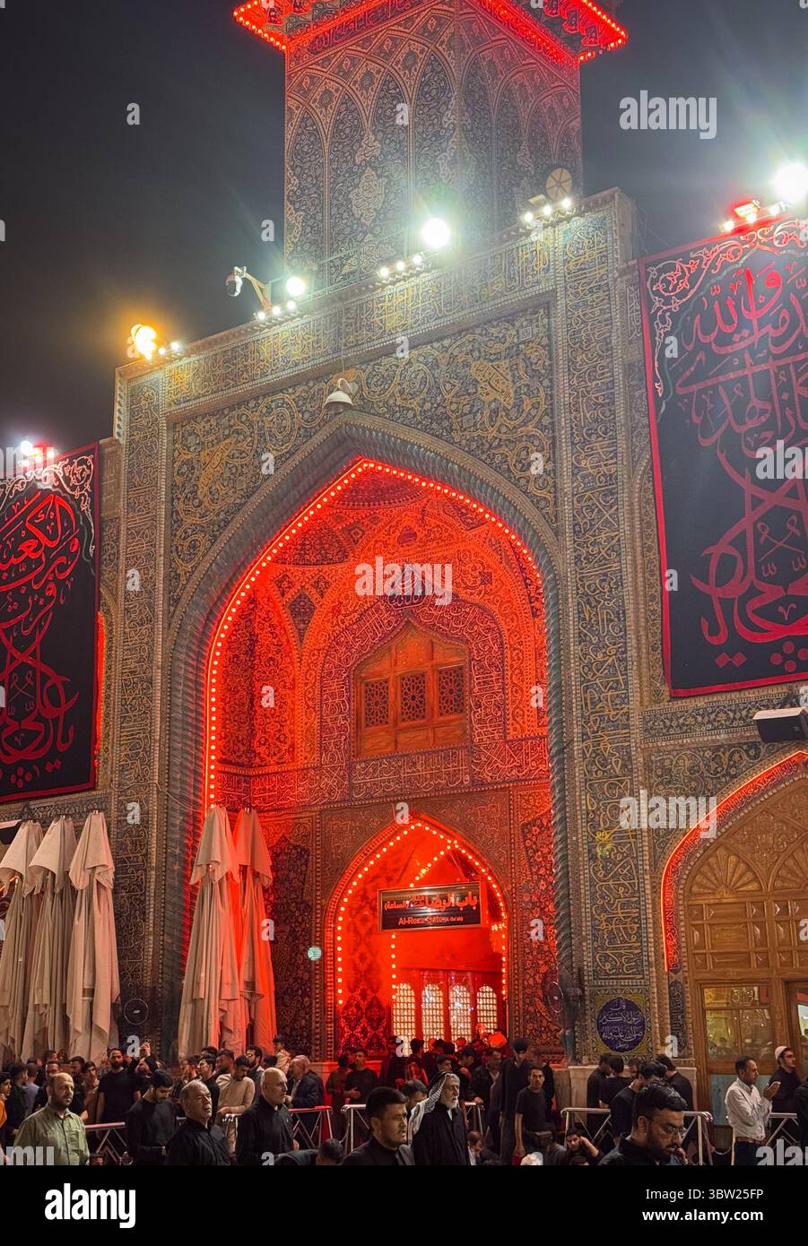 Visitors gather at the illuminated entrance of a mosque in An Najaf ...