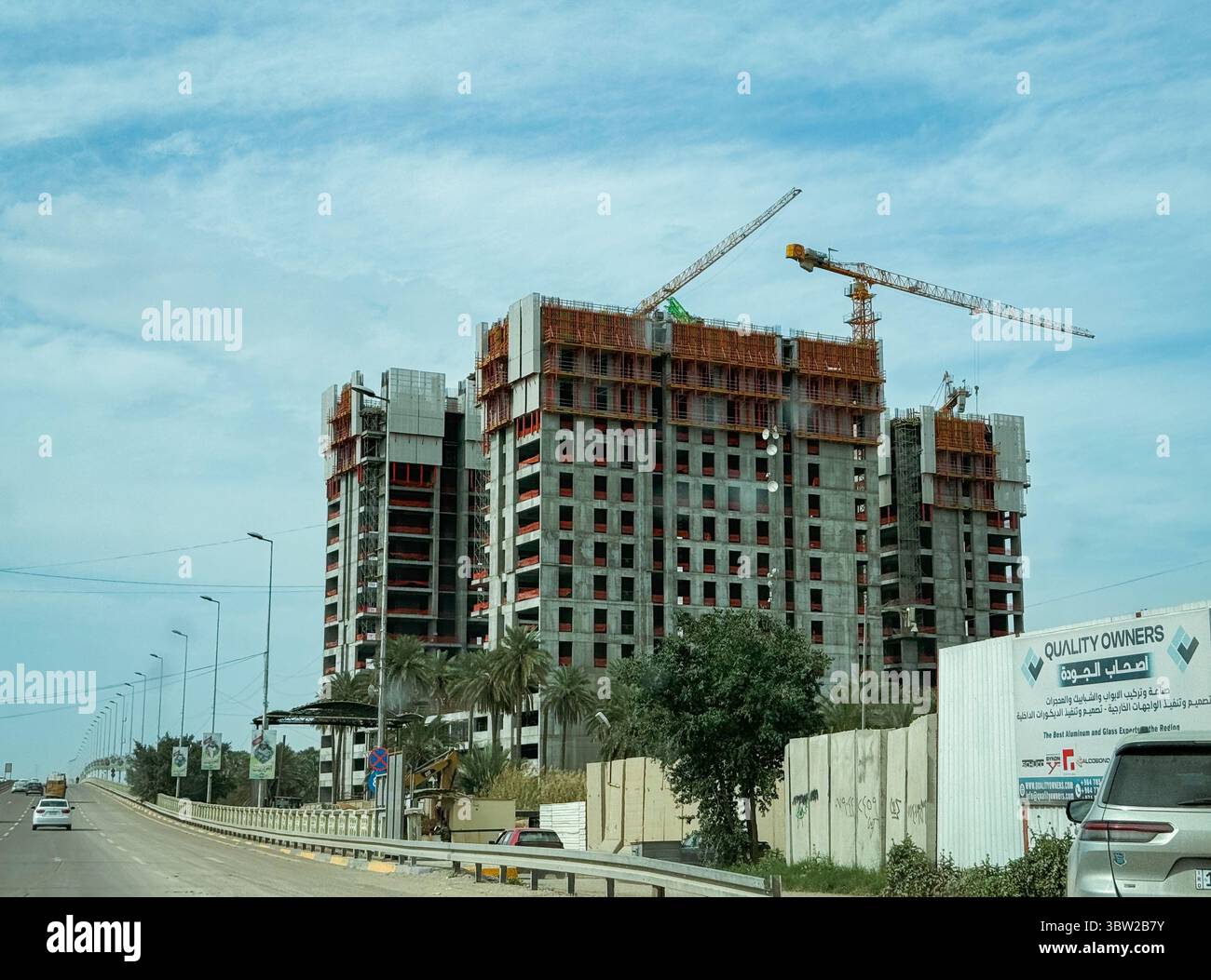 A high rise building is under construction in Baghdad, featuring cranes ...