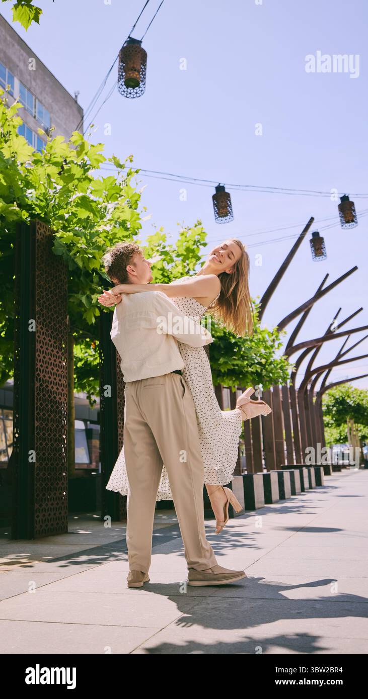Urban discovery. Young couple embraces joyfully outdoors under ...